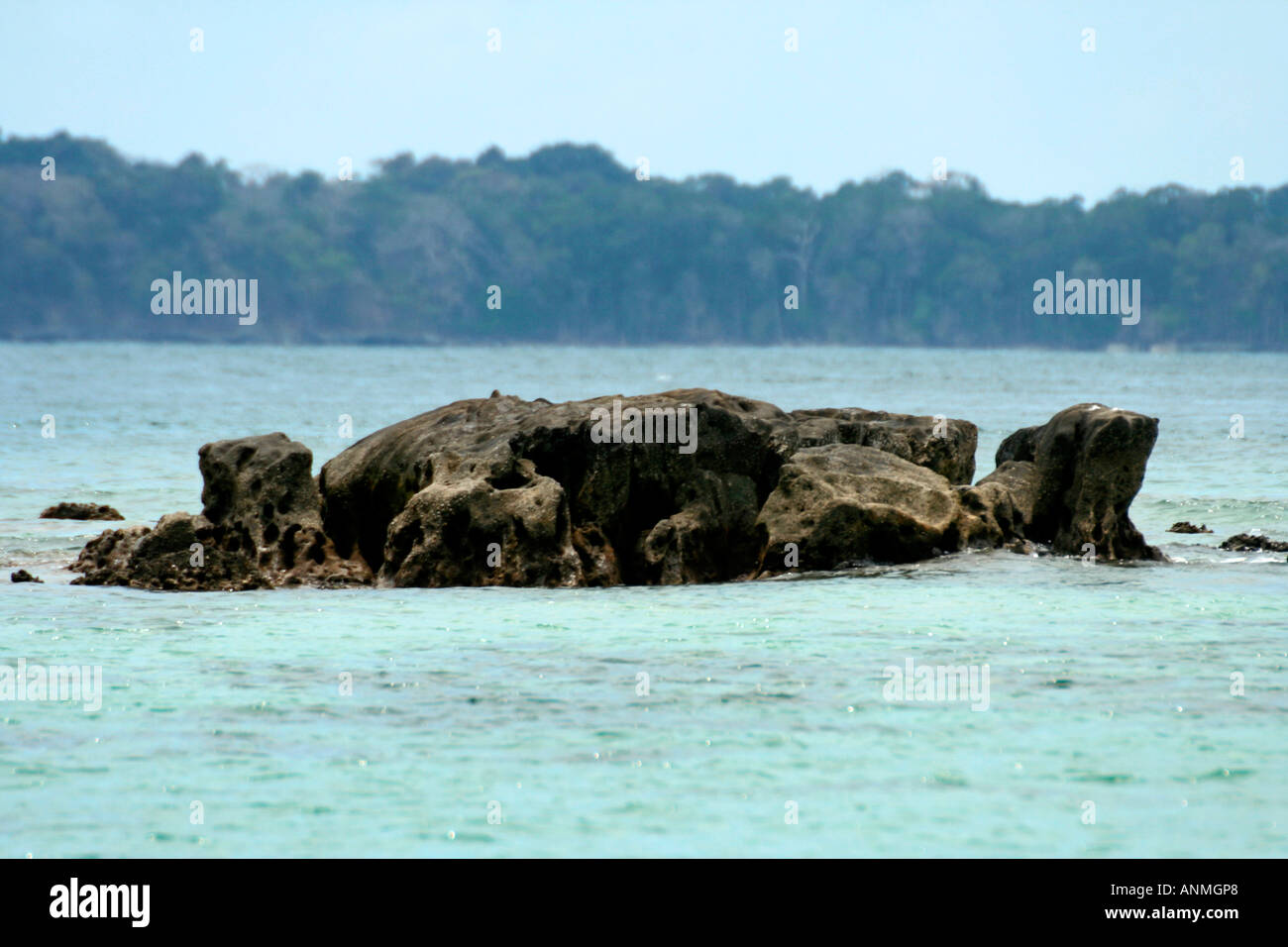 Rocks in mid sea with a view of forests in the distance in Jolly buoy ...