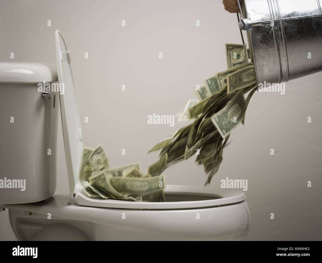 Person dumping money into a toilet bowl Stock Photo - Alamy