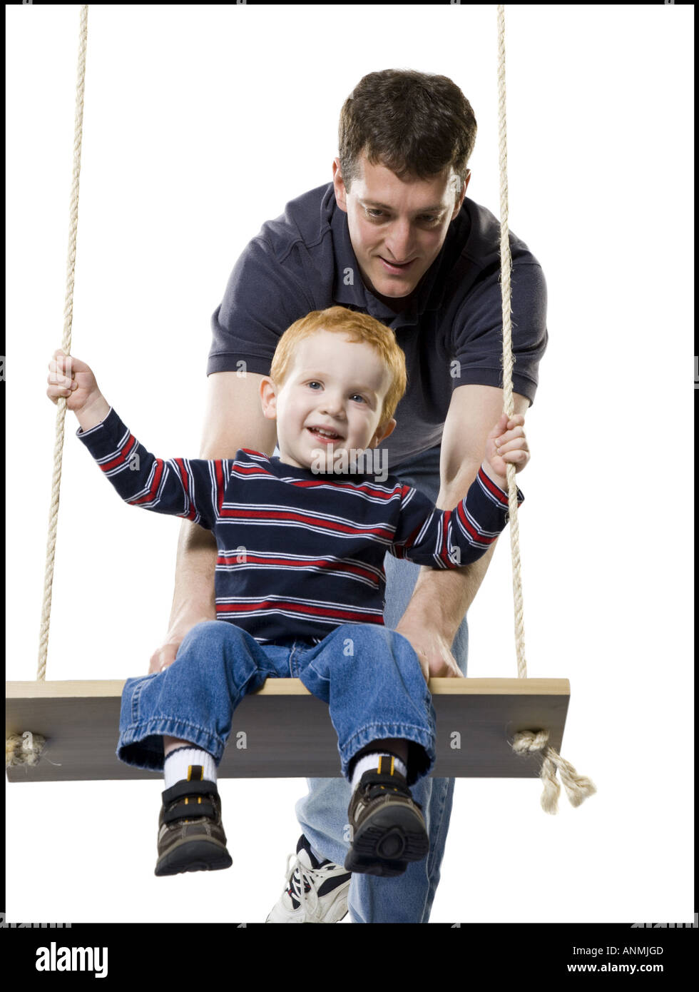Father pushing his son on a swing Stock Photo - Alamy