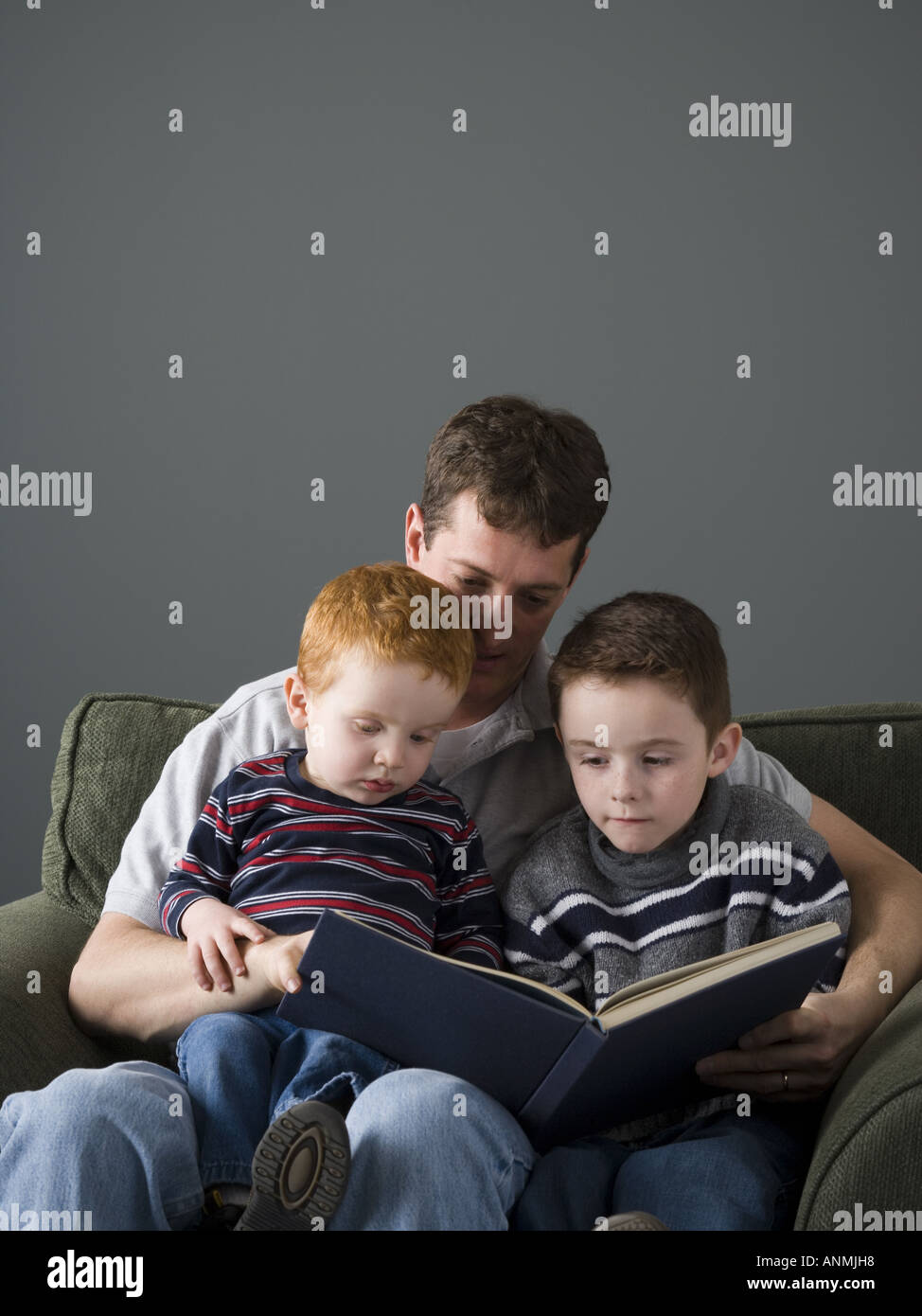 Father reading a book with his two sons Stock Photo - Alamy