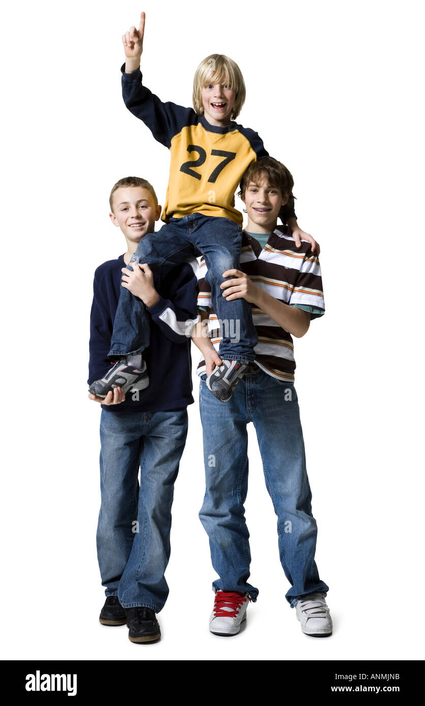 Portrait of two boys carrying a boy on their shoulders Stock Photo - Alamy