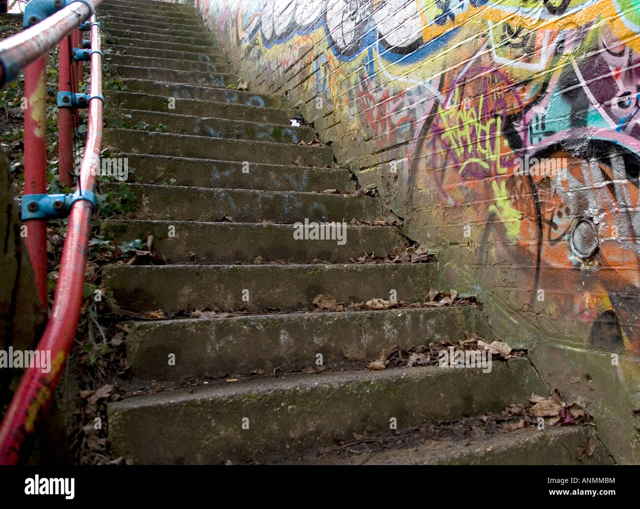 stone steps run alongside a wall with graffiti Stock Photo - Alamy