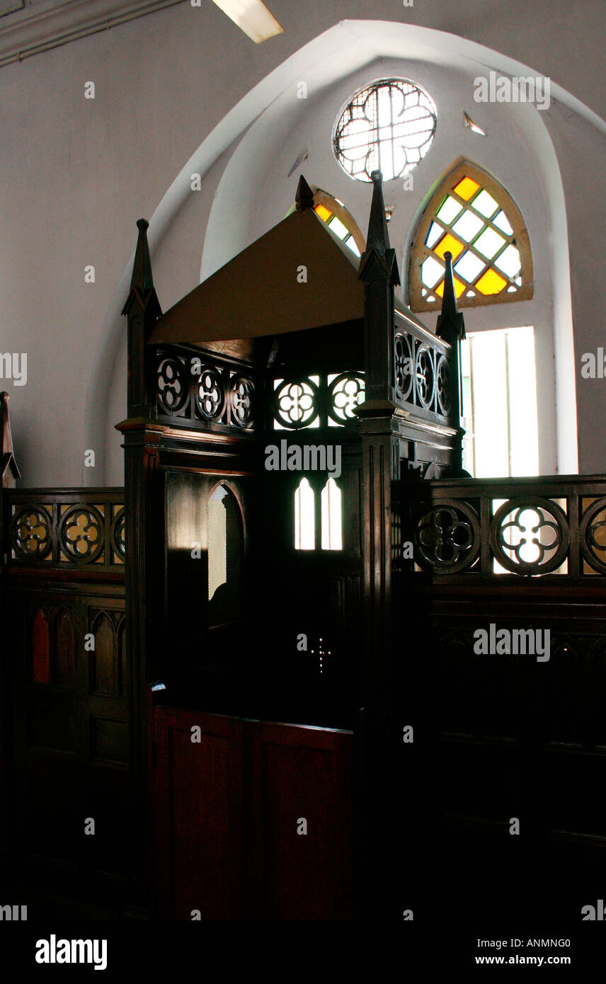 Light falling through a window on an ebony colored confessional against ...