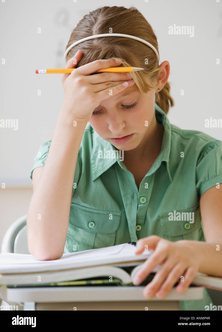 Teenaged girl reading at school desk Stock Photo - Alamy