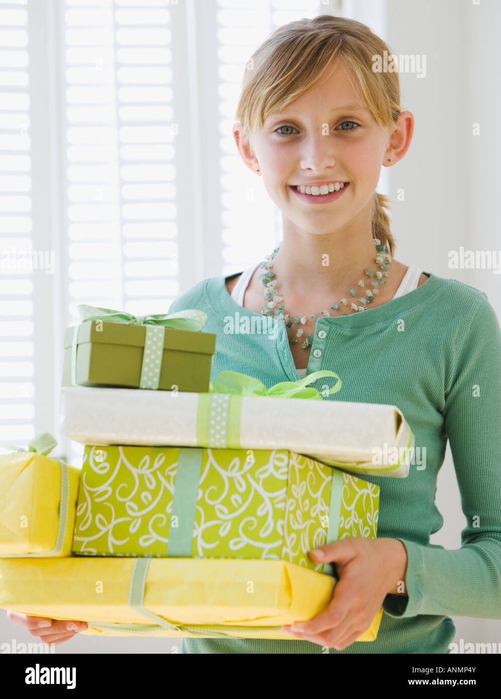 Teenaged girl holding stack of gifts Stock Photo - Alamy