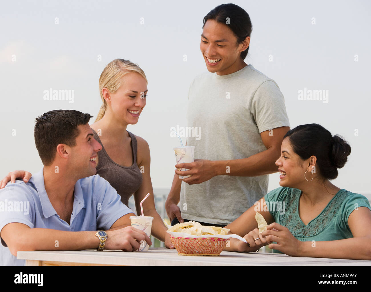 Multi-ethnic friends eating Stock Photo - Alamy