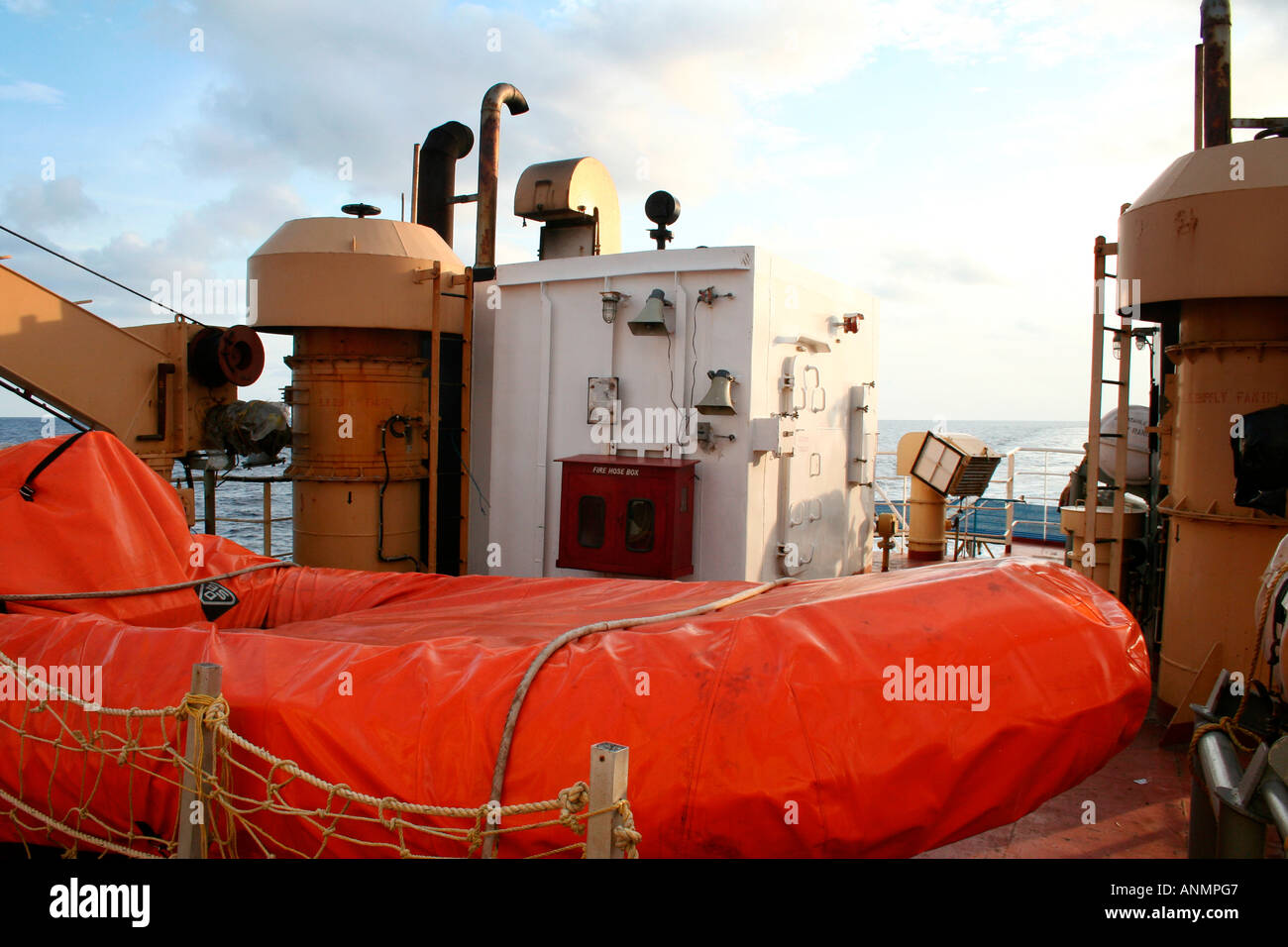 A lifeboat covered with a red plastic sheet and other machinery inside ...