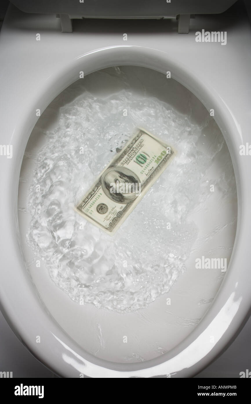 High angle view of an American dollar note floating in the toilet bowl ...
