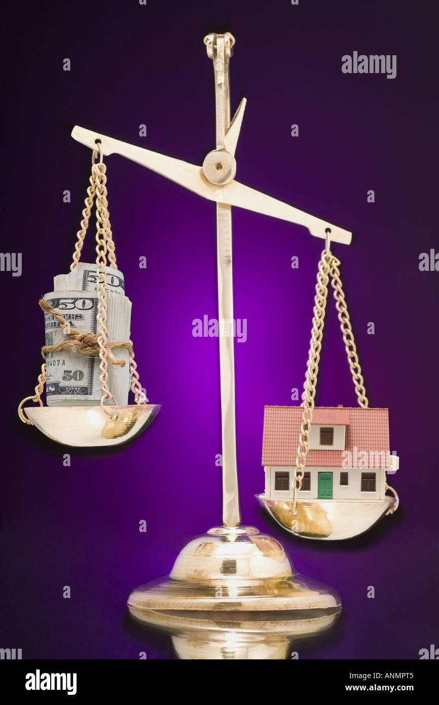 Paper currency and a model house on a weighing scale Stock Photo - Alamy