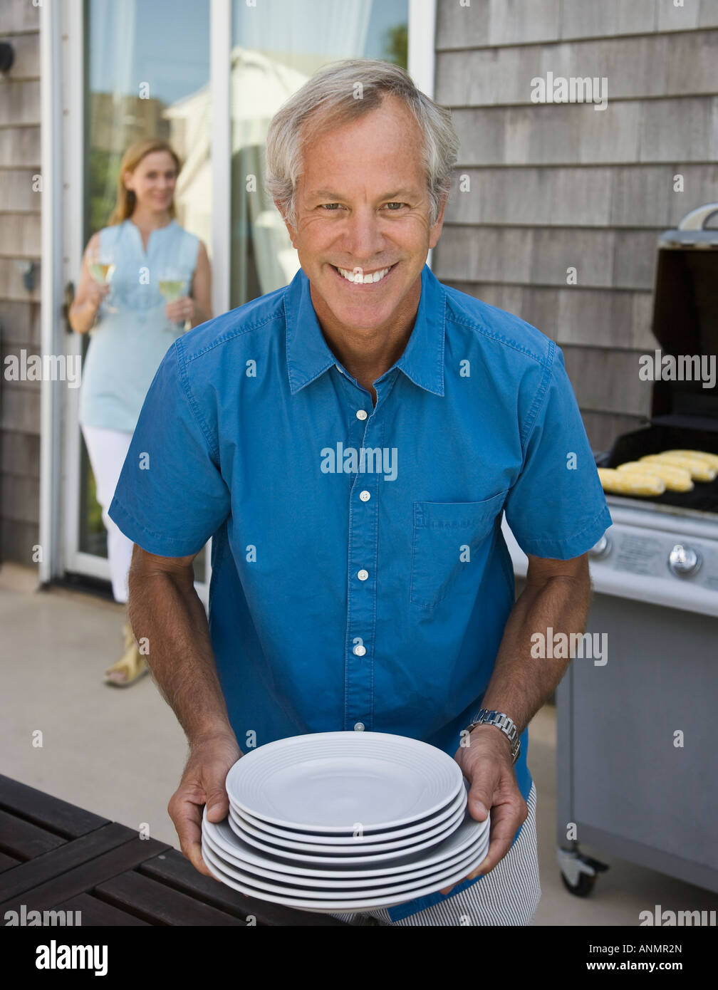 Man carrying stack of plates Stock Photo - Alamy