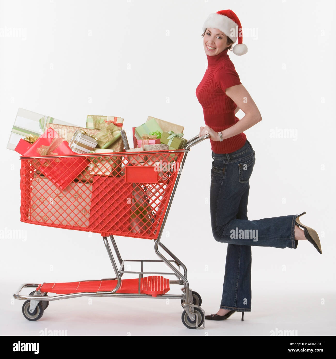 Woman pushing shopping cart of gifts Stock Photo - Alamy