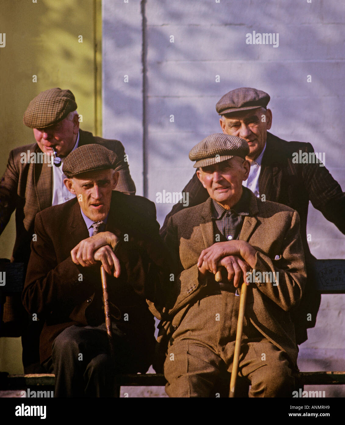 Group of older men passing the time on a village bench watching the ...