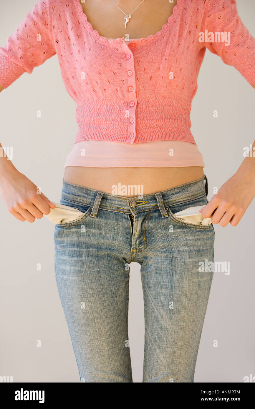 Young woman pulling out pockets Stock Photo - Alamy