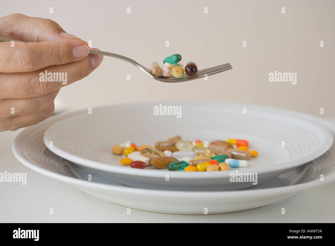 Man eating pills on fork Stock Photo - Alamy
