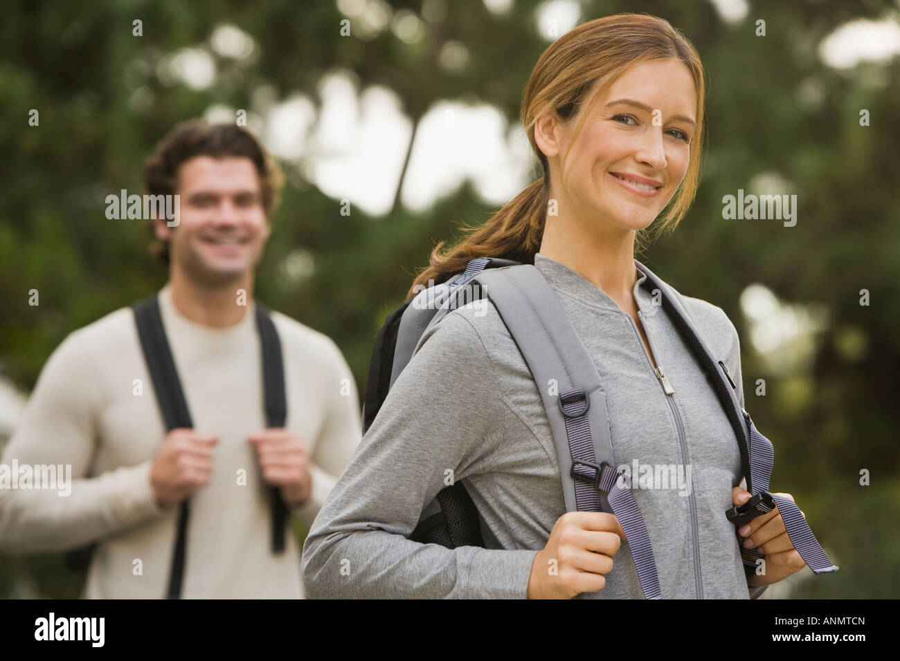 Couple wearing backpacks in woods Stock Photo - Alamy