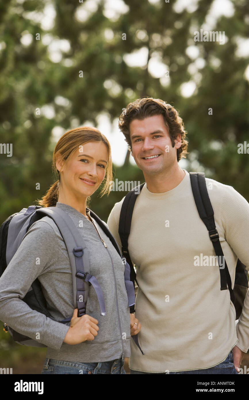 Couple wearing backpacks in woods Stock Photo - Alamy