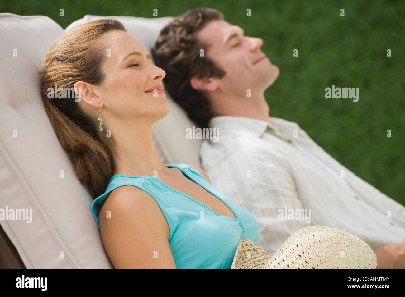 Couple laying in lounge chairs Stock Photo - Alamy