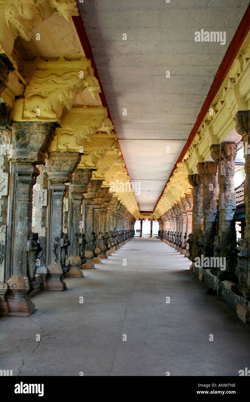 A long passage lined on both sides by stone pillars with sculptures in ...