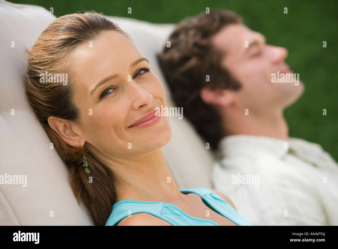 Couple laying in lounge chairs Stock Photo - Alamy
