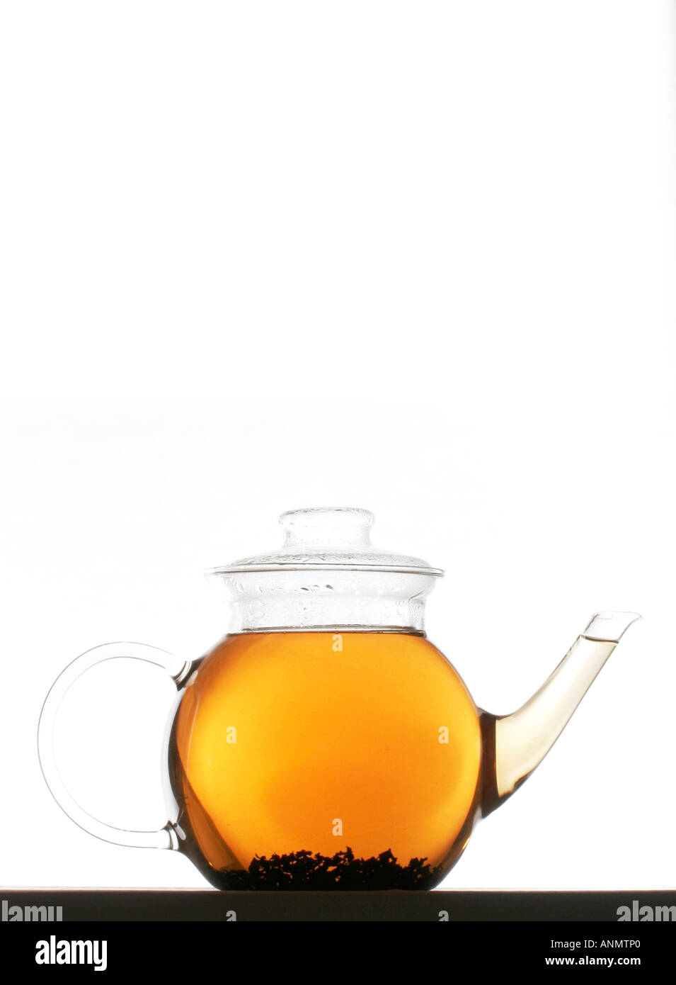 Glass pot of golden colored tea isolated against white background Stock ...