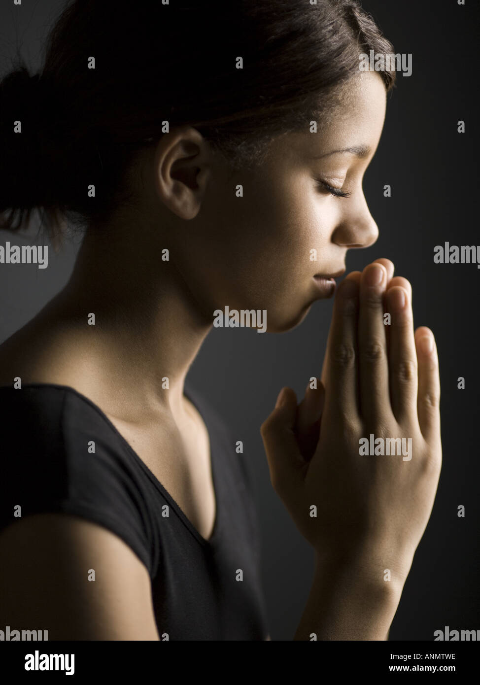 Profile of a girl in a prayer position Stock Photo - Alamy