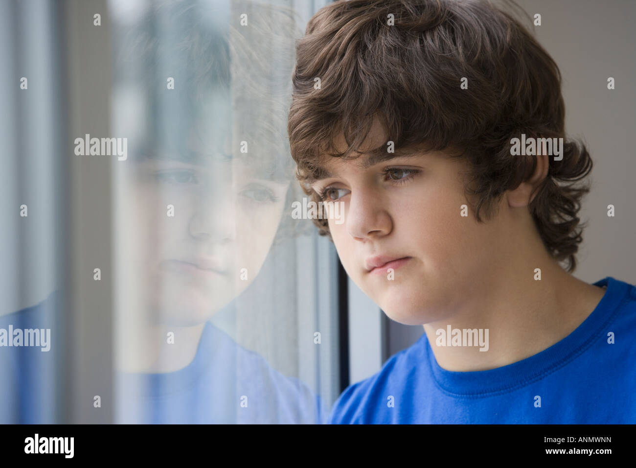 Teenaged boy looking out window Stock Photo - Alamy