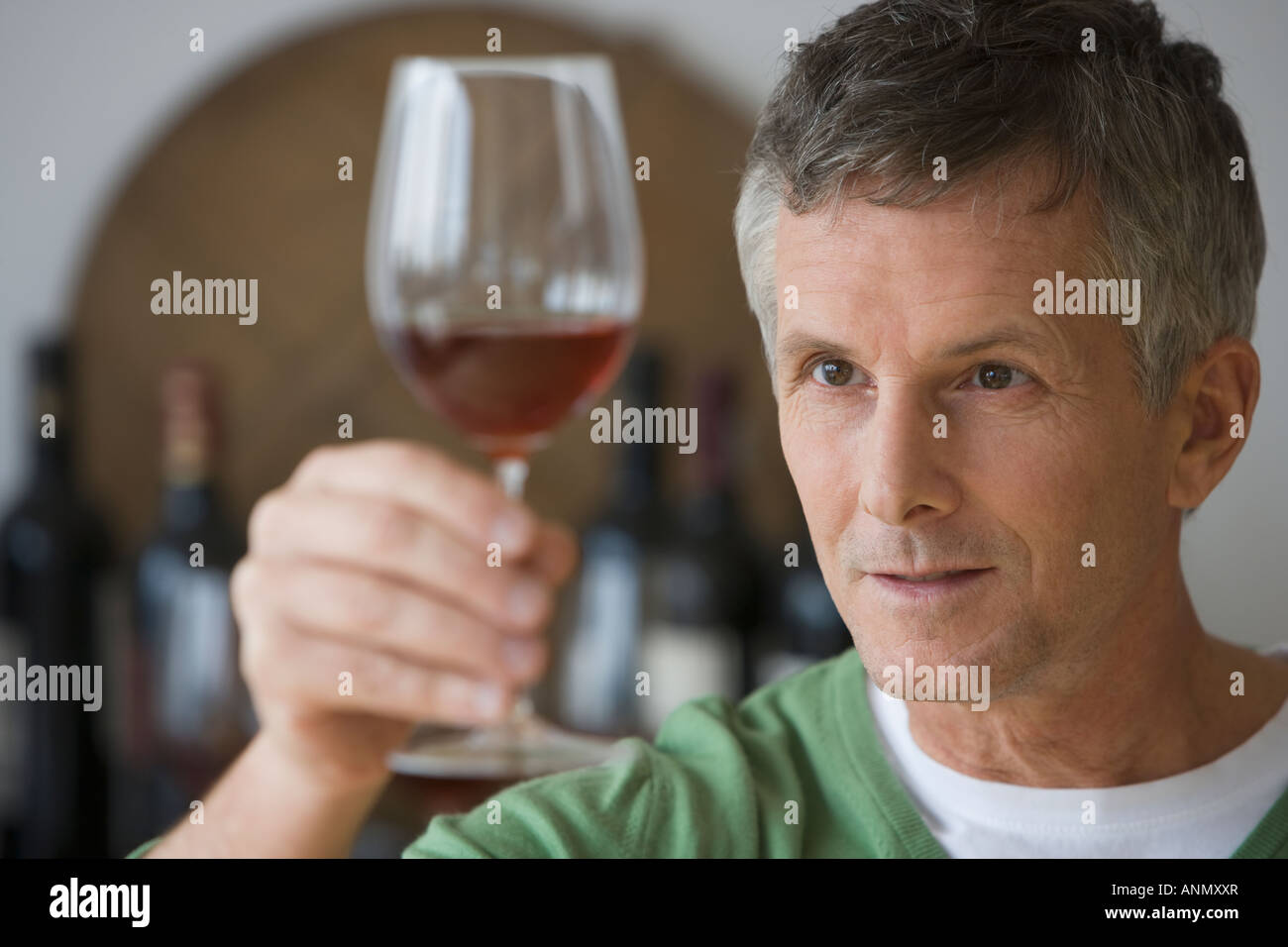 Man looking at glass of wine Stock Photo - Alamy