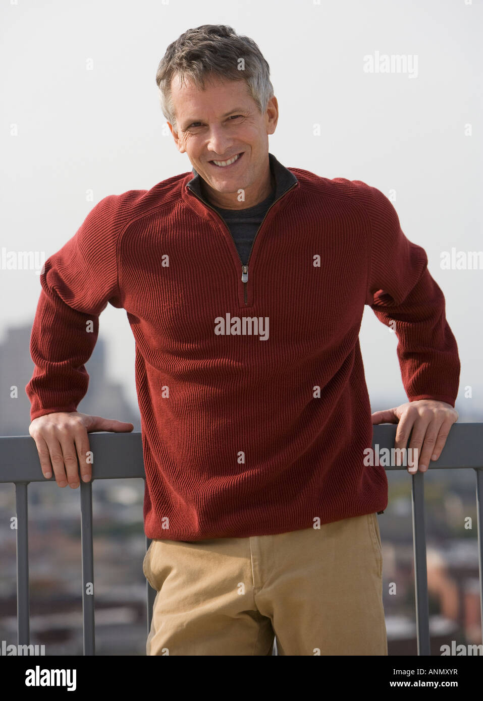 Man leaning on balcony railing Stock Photo - Alamy