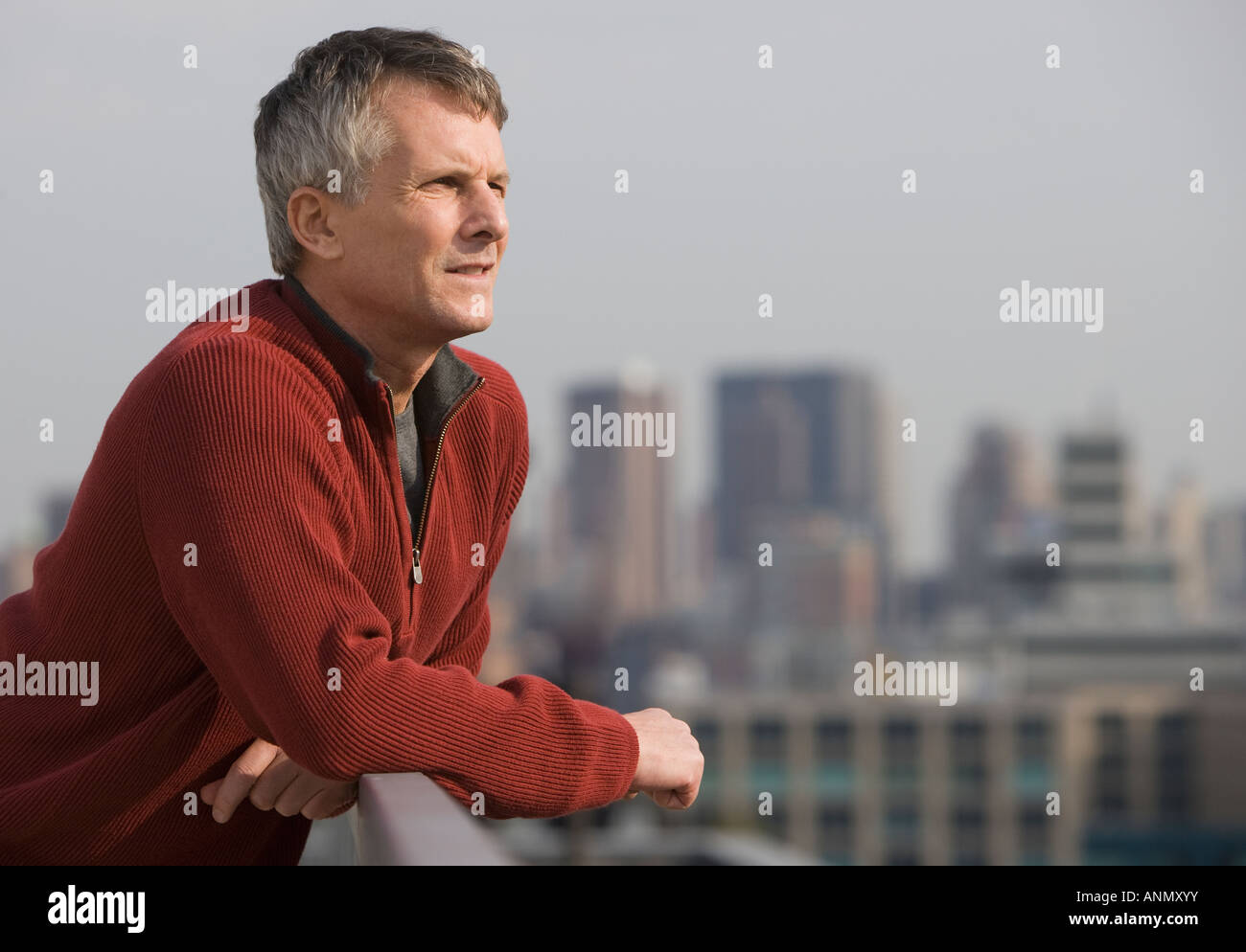 Man leaning on balcony railing Stock Photo - Alamy