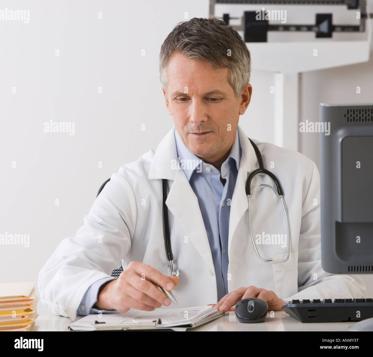Male doctor writing on chart Stock Photo - Alamy