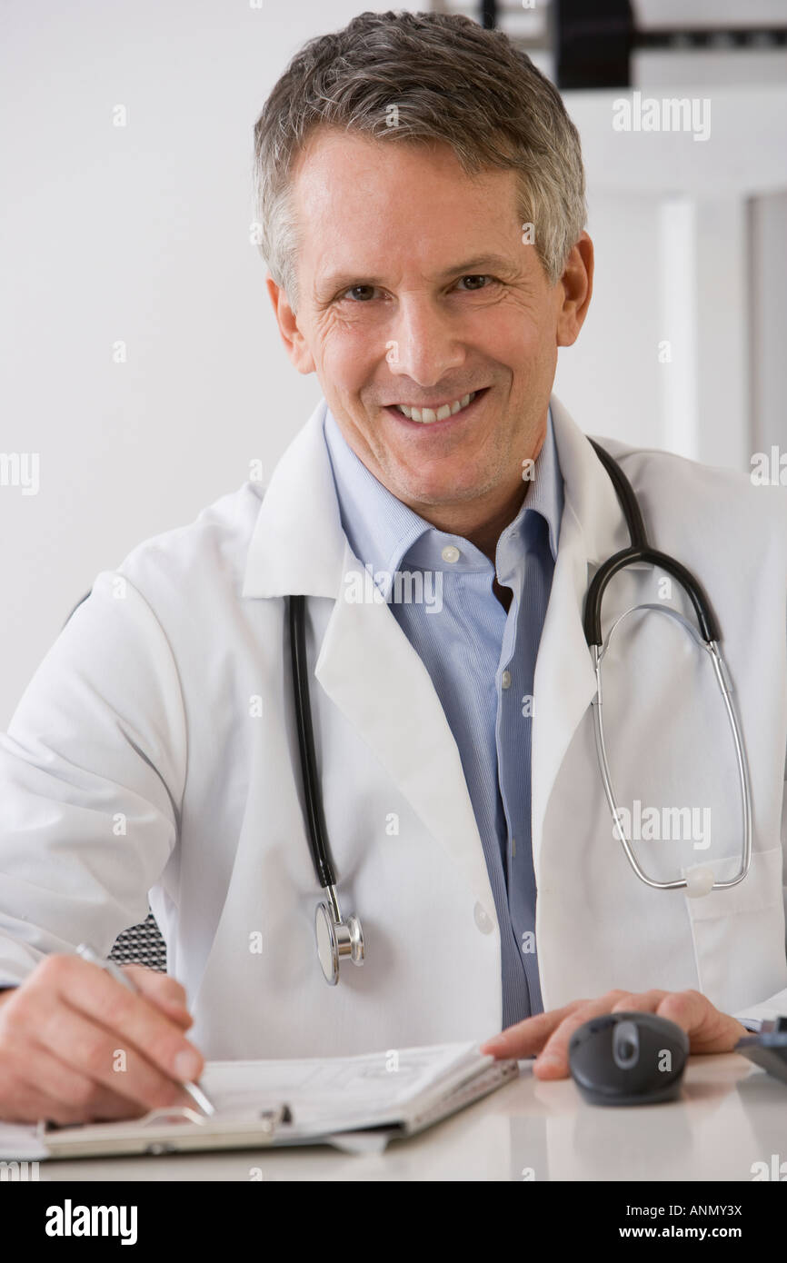 Male doctor writing on chart Stock Photo - Alamy