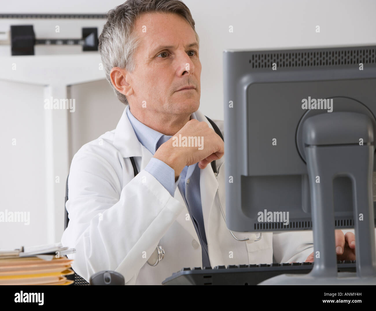 Male doctor looking at computer Stock Photo - Alamy