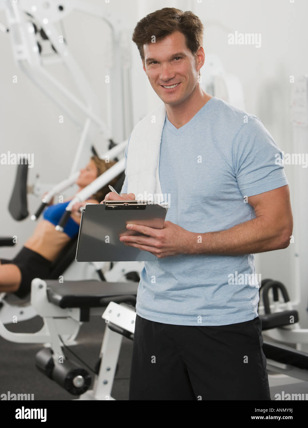 Male personal trainer writing on chart Stock Photo - Alamy