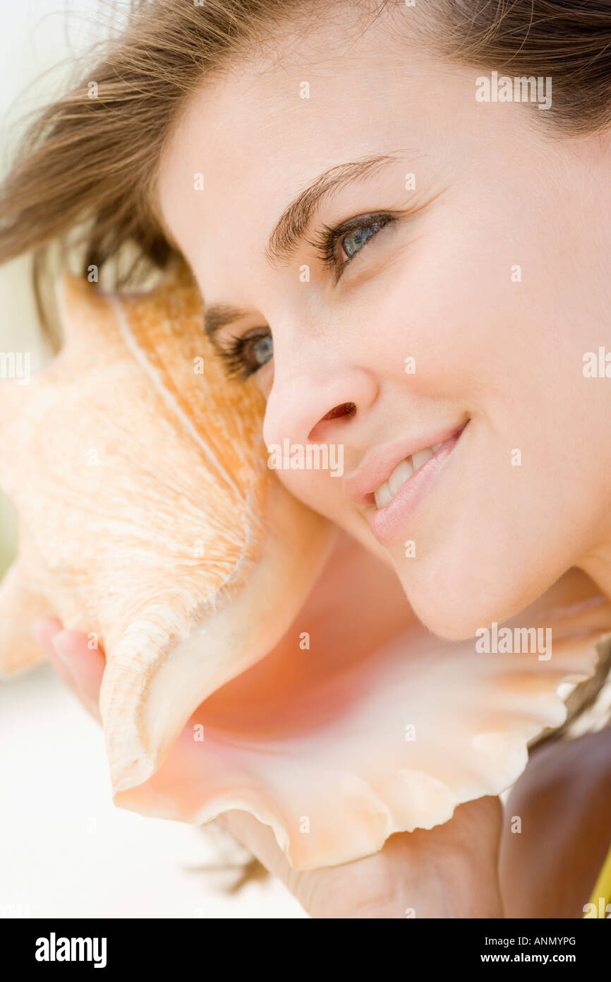 Woman listening to conch shell Stock Photo - Alamy