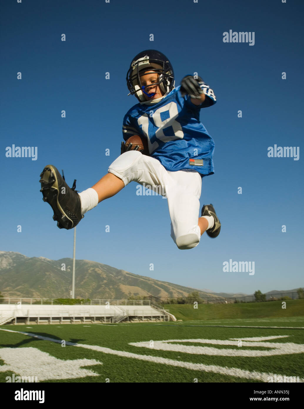 Young football player jumping Stock Photo - Alamy