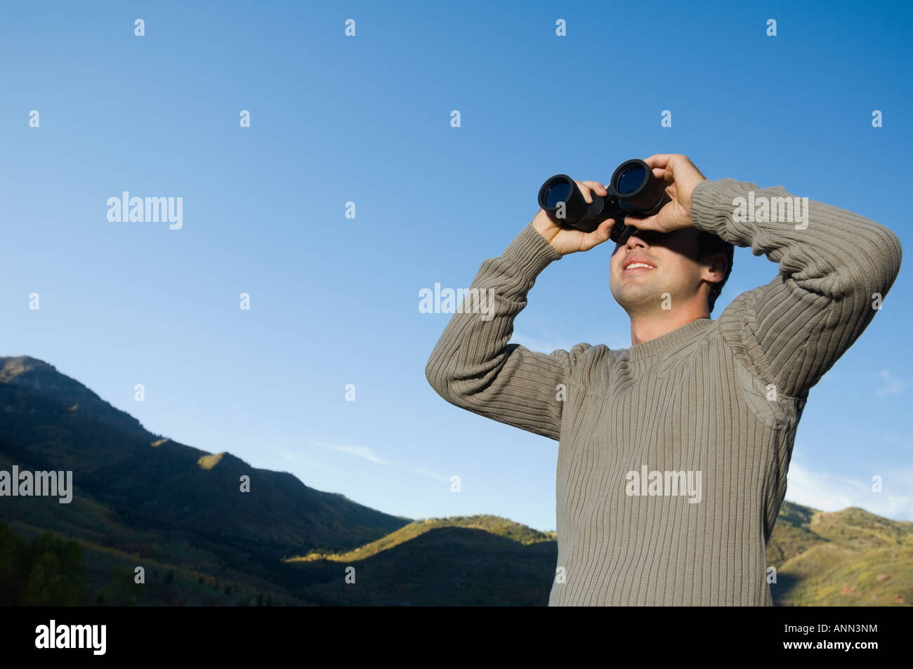 Man looking through binoculars, Utah, United States Stock Photo - Alamy