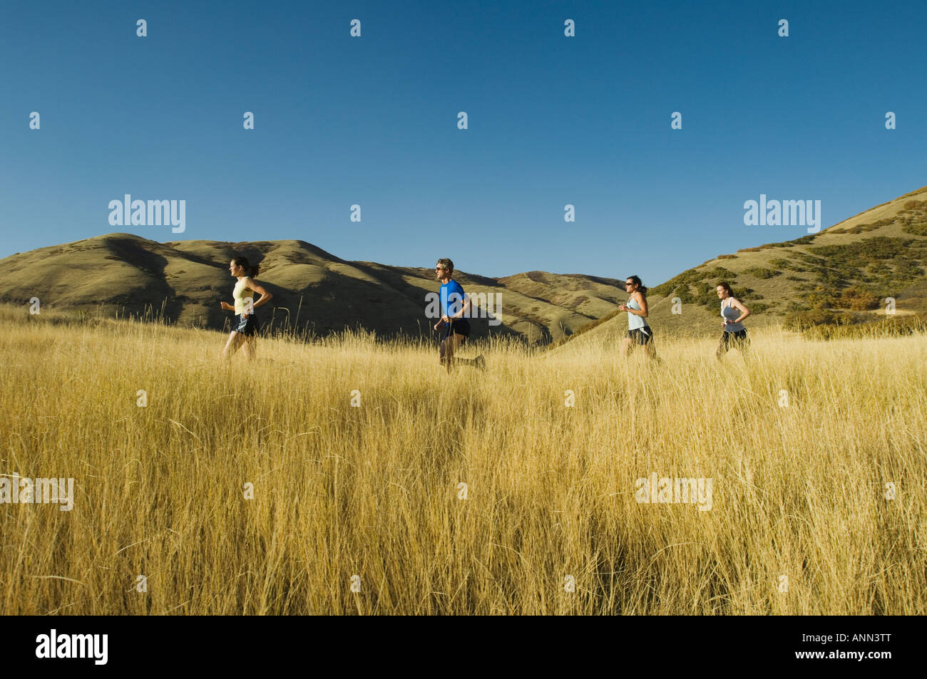 Group of people running in field, Utah, United States Stock Photo - Alamy