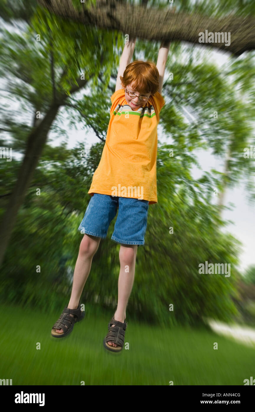 Boy hanging on branch tree hi-res stock photography and images - Alamy