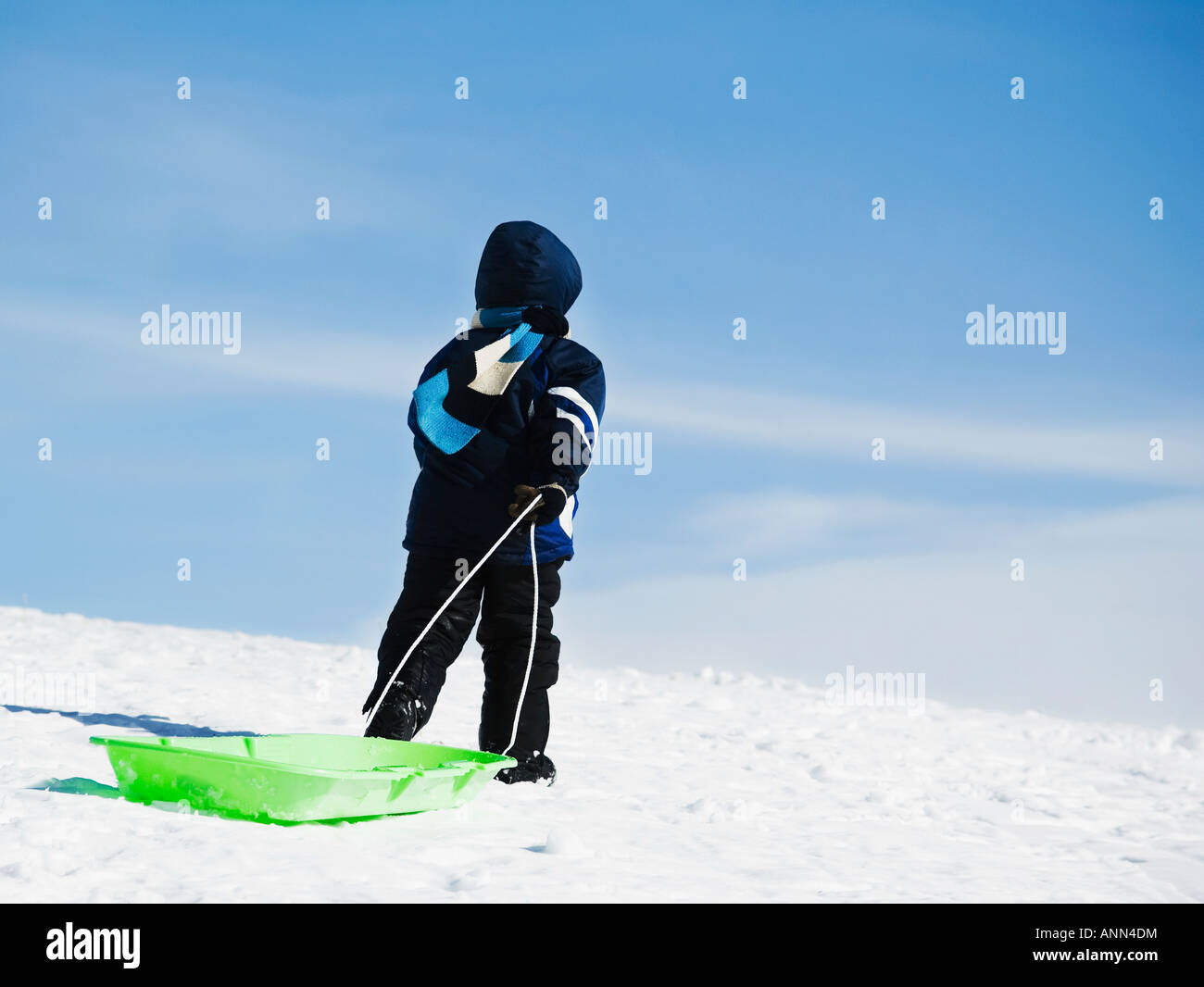 Child pulling sled in snow Stock Photo - Alamy