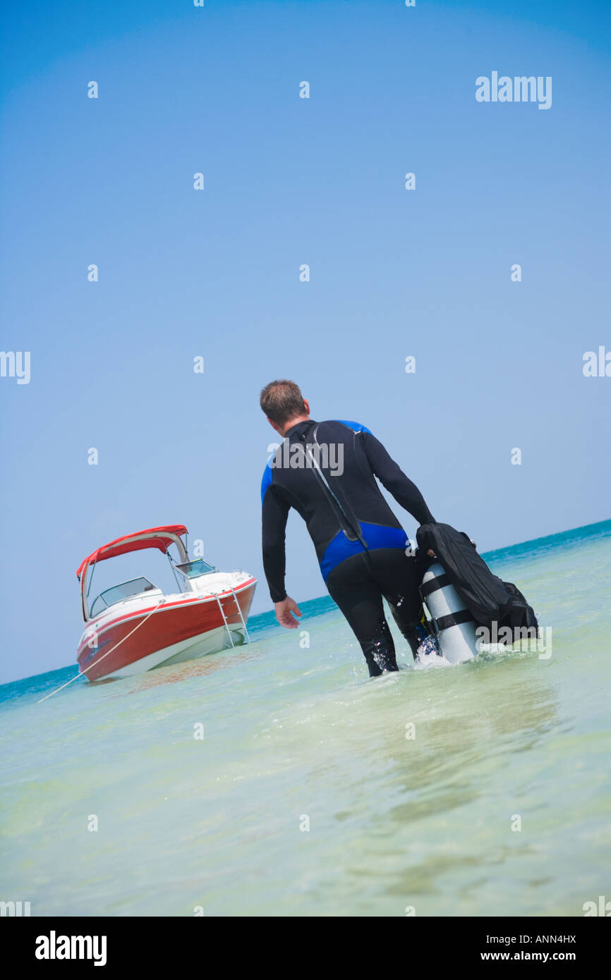Man carrying scuba gear towards boat, Florida, United States Stock ...