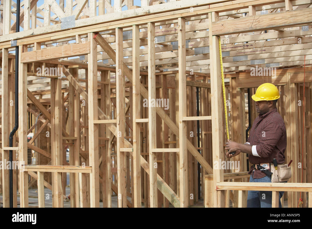 Construction Worker measuring boards on Site Stock Photo - Alamy