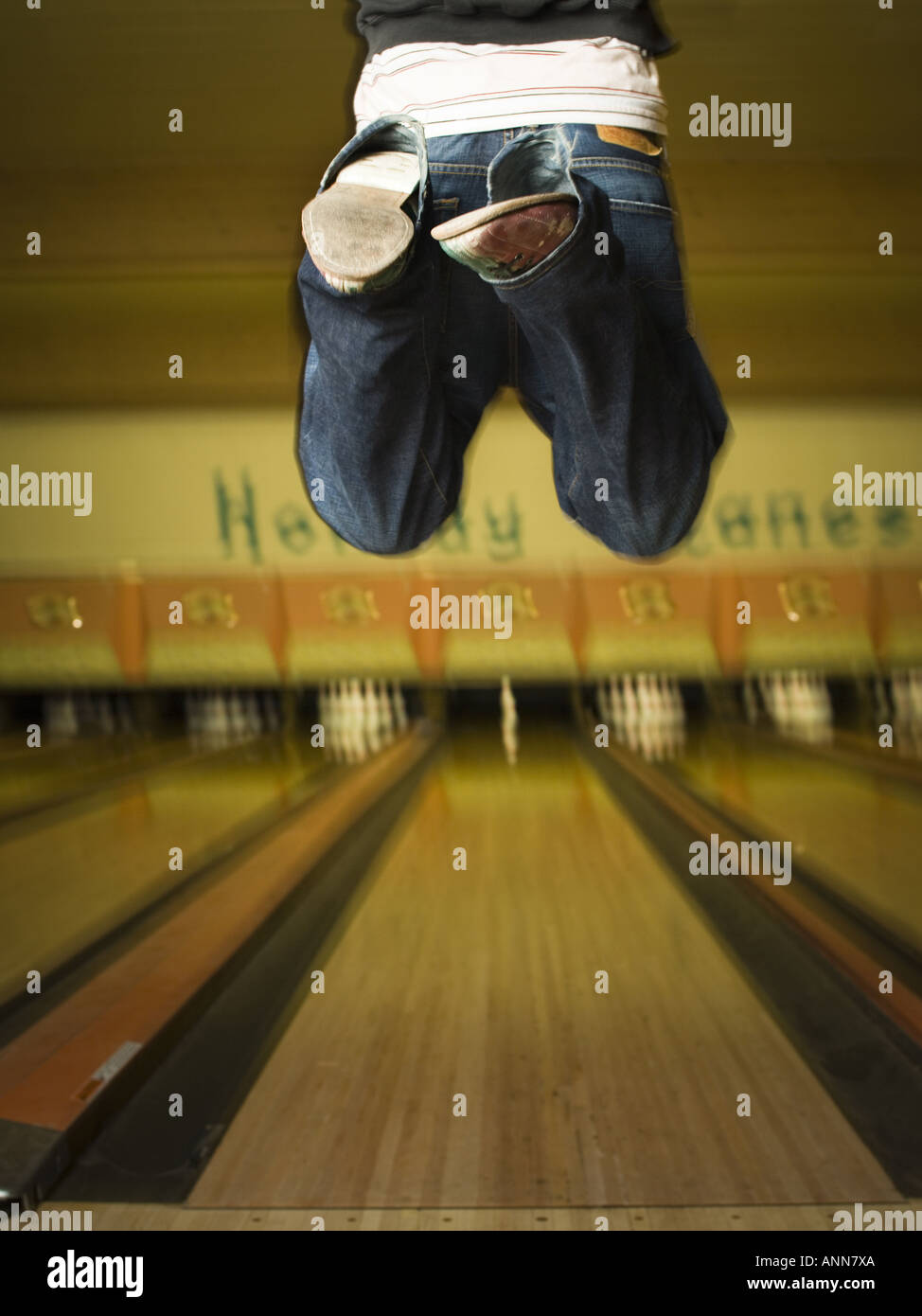 Low section view of a young man jumping at a bowling alley Stock Photo ...