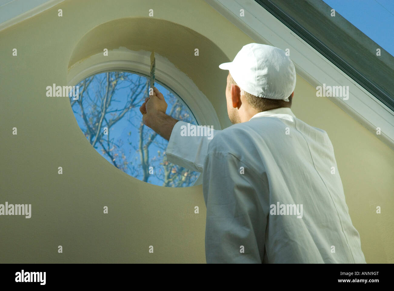 male painter concentrates on painting interior wall near window Stock ...