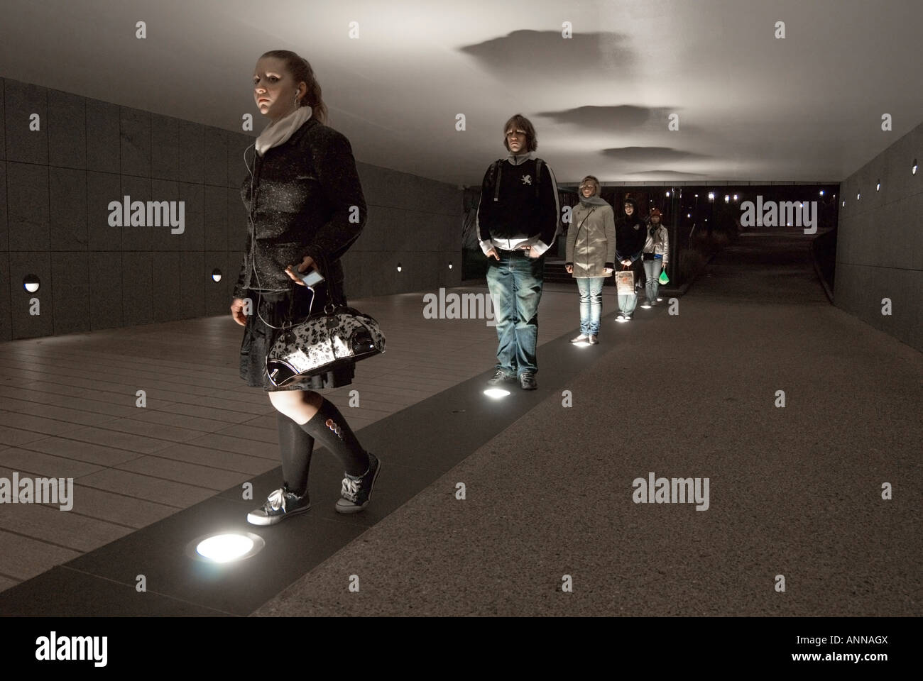 Group of American teenagers stand in a pedestrian underpass at night ...
