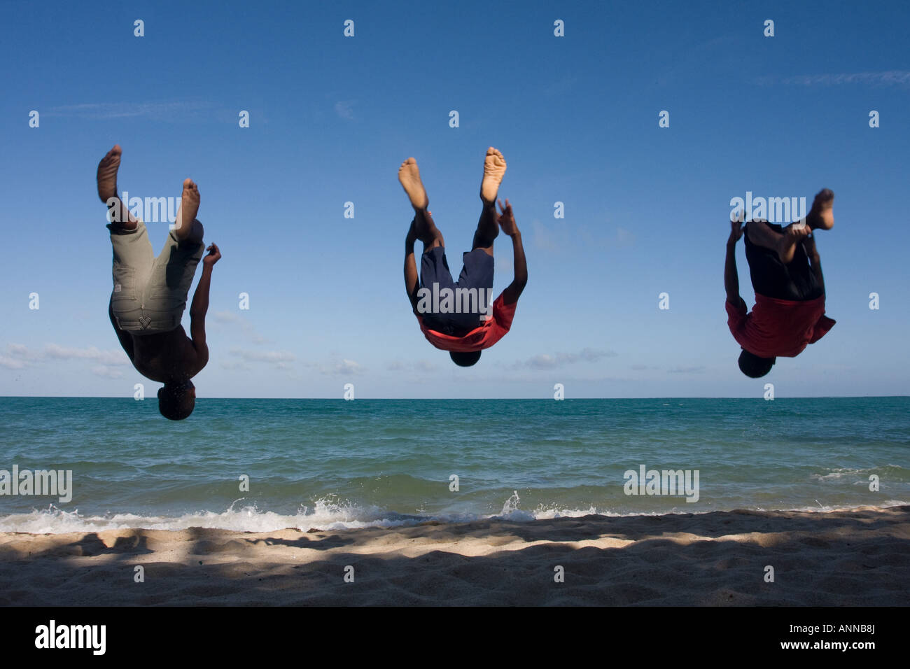 Three boys performing back flips on a beach Stock Photo - Alamy
