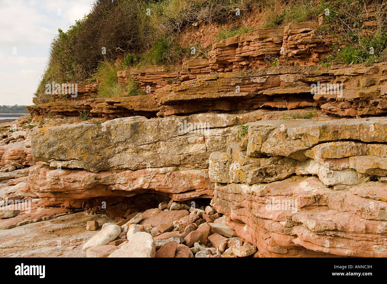 Tidal erosion undermining limestone rock strata Sully beach SE Wales ...