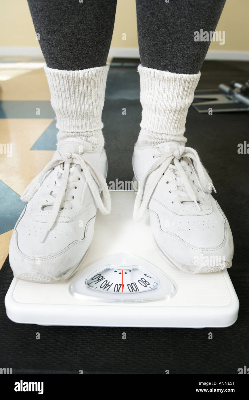 Senior woman standing on weighing machine in the gym Stock Photo - Alamy