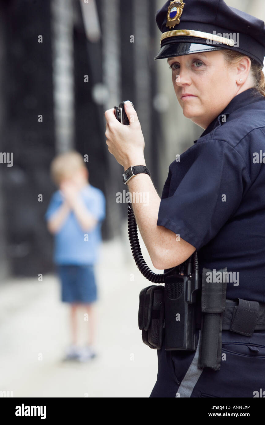 Woman police officer talking on hand mike Stock Photo - Alamy