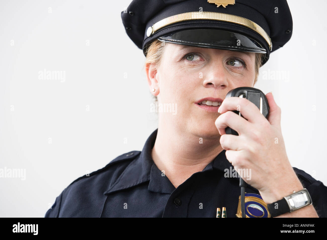 Woman police officer talking on hand mike Stock Photo - Alamy