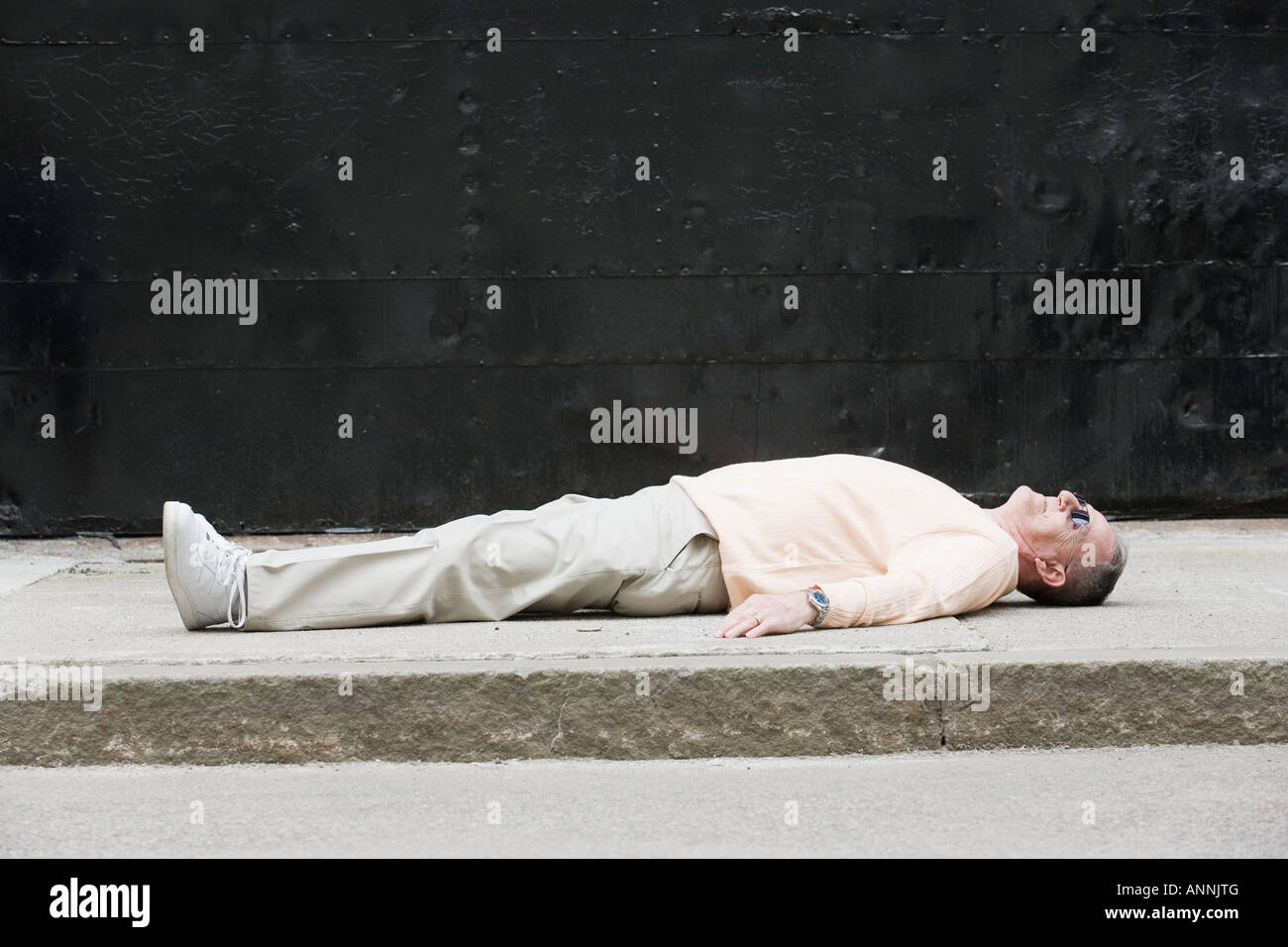 Senior man lying on a road Stock Photo - Alamy